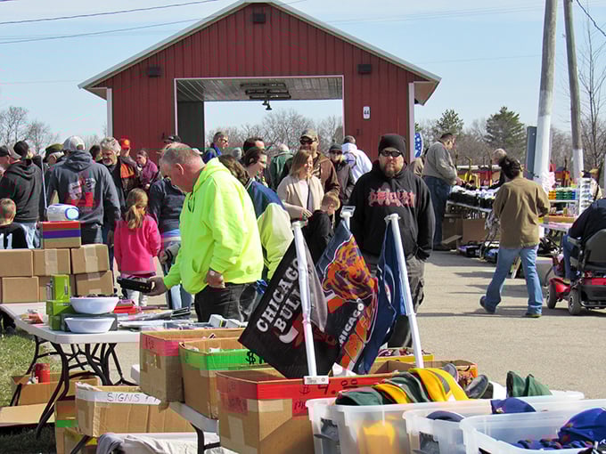 Flea market crowds doing the Wisconsin shuffle—part bargain hunt, part social hour, all under the watchful eye of a classic red barn.