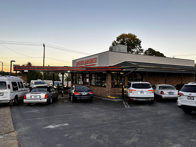 Sunset casts a golden glow on Pizza Palace. When a parking lot's this full at dusk, you know the pizza's worth the wait.