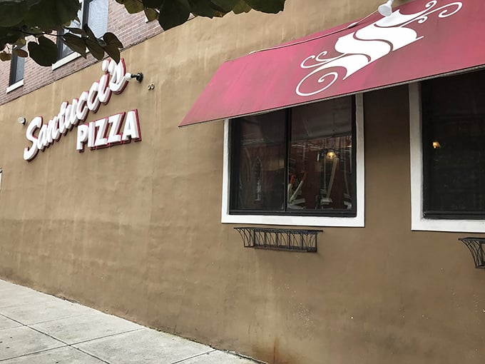 That iconic burgundy awning signals you've arrived at square pizza paradise – where sauce-on-top creates flavor that defies gravity.