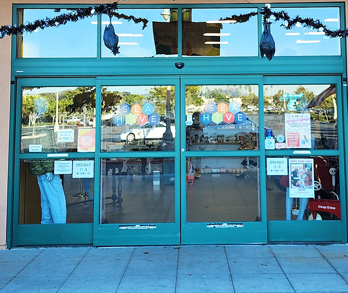 The turquoise entrance doors offer a portal to nostalgia, with the colorful Sea Hive logo promising adventures in vintage shopping.