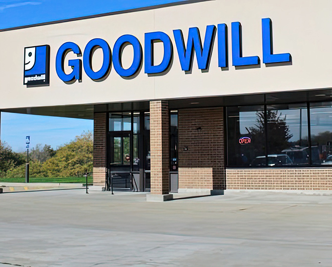 The smiling Goodwill logo isn't just branding—it's foreshadowing the expression you'll wear after scoring vintage vinyl for less than a gas station coffee.