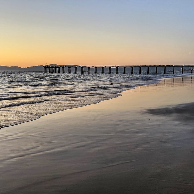 Golden hour transforms the pier into a watercolor painting that would make Bob Ross reach for his happy brushes.