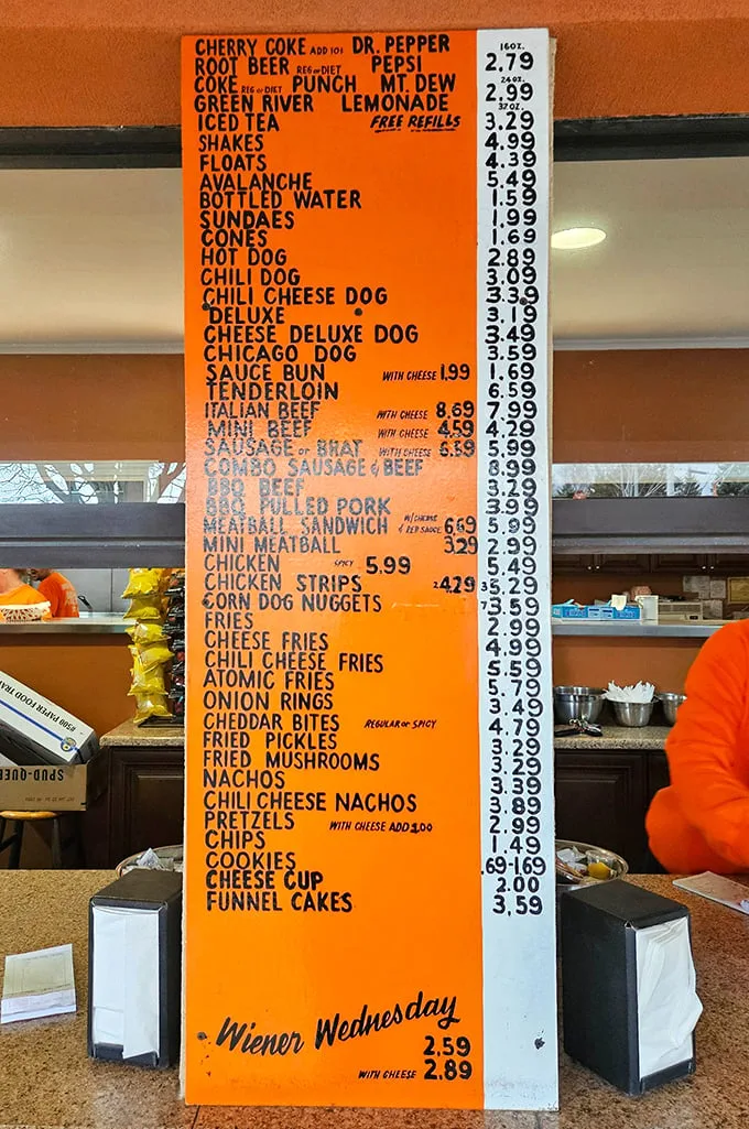 The bright orange menu board – a masterpiece of Midwestern minimalism where every item promises satisfaction without a hint of pretension.