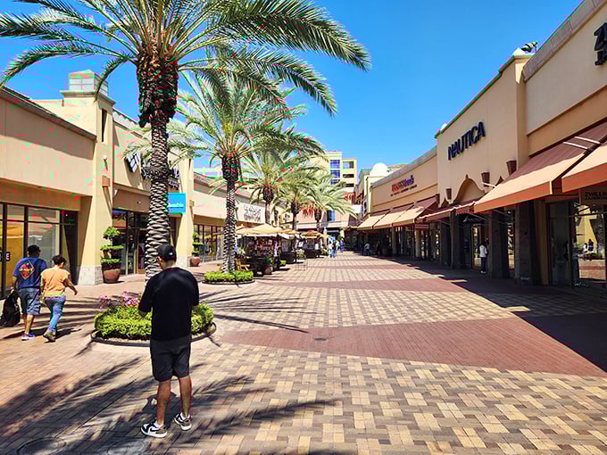 Sunlight bathes the wide promenades where shoppers stroll between stores, palm trees providing shade for those who've shopped until they're about to drop.