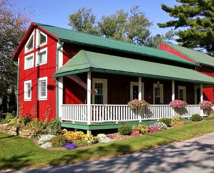 This isn't a painting from a Hallmark card—it's an actual red barn with a white porch where real people make real food without a single food stylist in sight. 