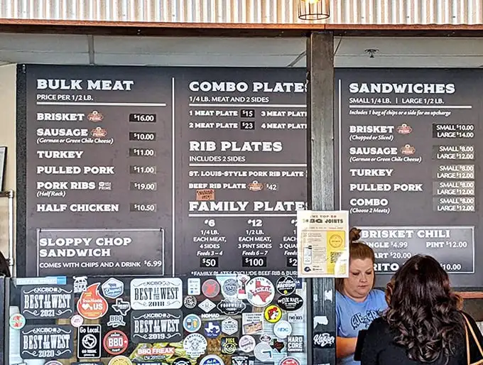The menu board—a sacred text for carnivores—promises smoky salvation in the form of ribs, brisket, and sausage.