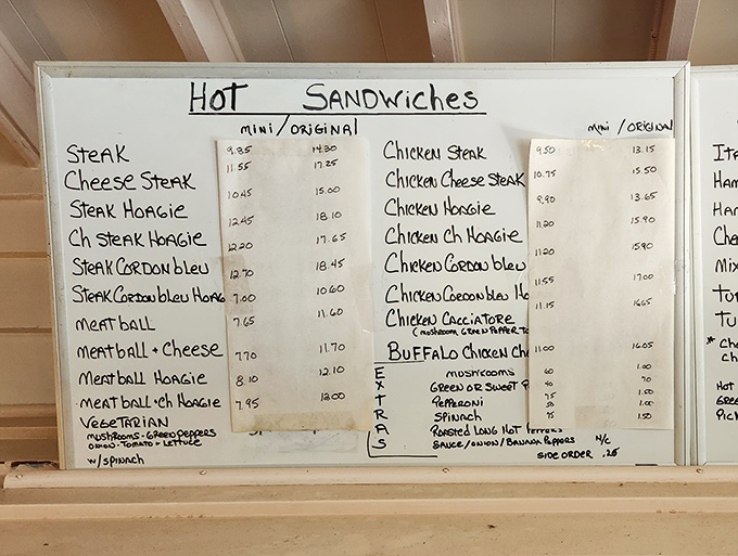 The handwritten menu board—a relic from a pre-digital age—showcases an impressive lineup of hot sandwiches that have stood the test of time.