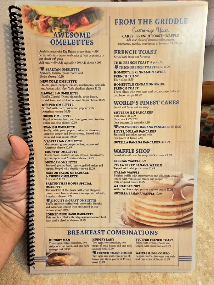 The menu – a spiral-bound bible of breakfast possibilities. That "Biscuits & Gravy Omelet" isn't just a meal, it's a stroke of culinary genius that deserves its own Nobel Prize.