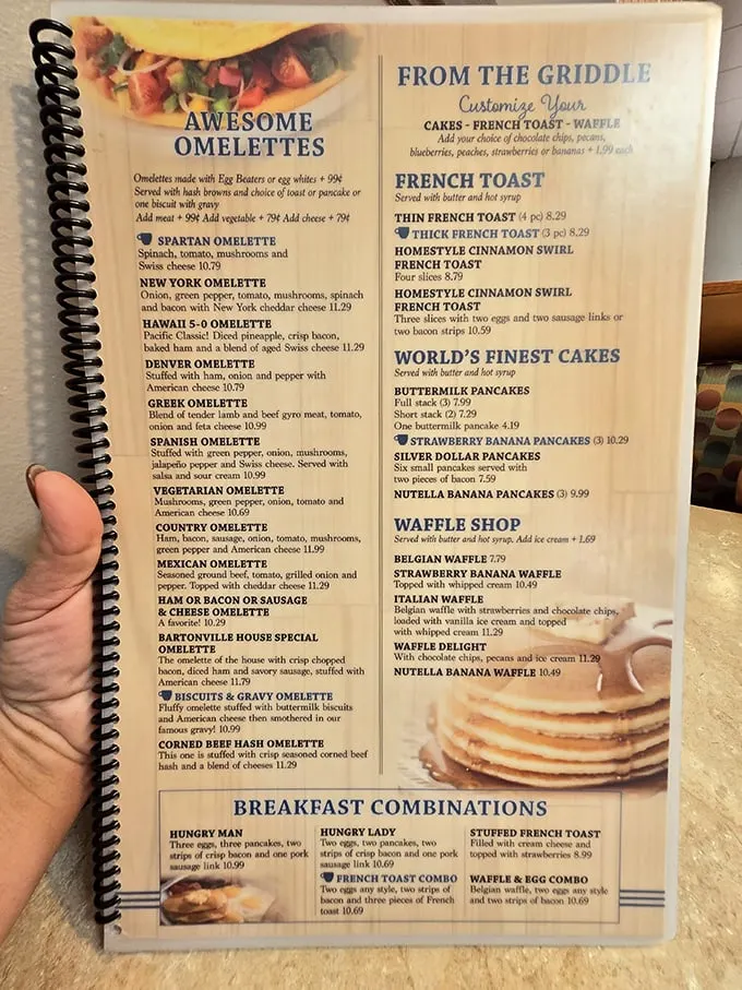 The menu – a spiral-bound bible of breakfast possibilities. That "Biscuits & Gravy Omelet" isn't just a meal, it's a stroke of culinary genius that deserves its own Nobel Prize.