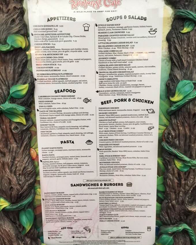 The menu is framed by faux tree bark—because nothing says "authentic jungle experience" like laminated food options nestled in synthetic wood.
