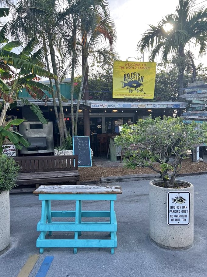 Hogfish Bar & Grill's tropical entrance with vibrant flowers says "vacation mode activated" before you even taste the food.