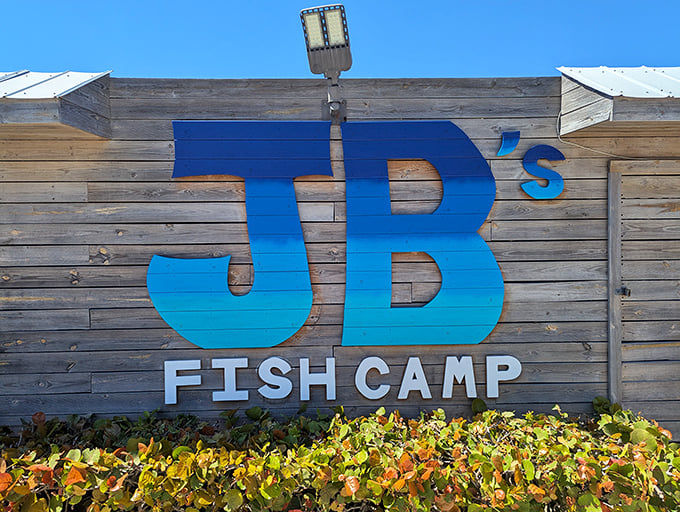 The blue "JB's Fish Camp" sign against weathered wood – nature's way of saying "authentic seafood ahead!"