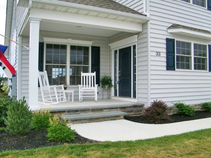 White rocking chairs standing at attention—retirement's version of a red carpet welcome. This porch practically begs for lemonade and gossip sessions.