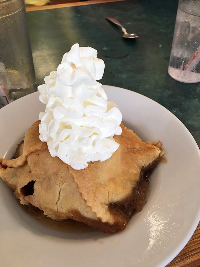 The apple dumpling arrives like a warm hug on a plate – flaky pastry, tender fruit, and that mountain of whipped cream that says "diet tomorrow, indulge today."