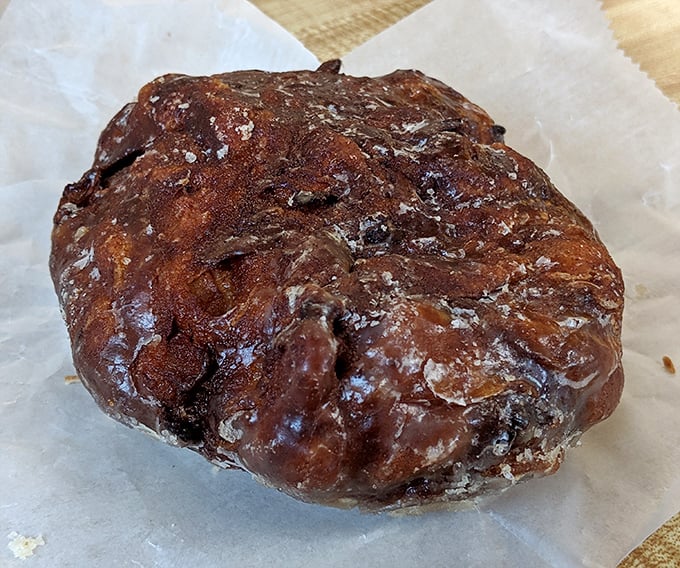This apple fritter isn't just a donut – it's an architectural marvel of caramelized edges, apple chunks, and glaze that would make Frank Lloyd Wright weep with joy.