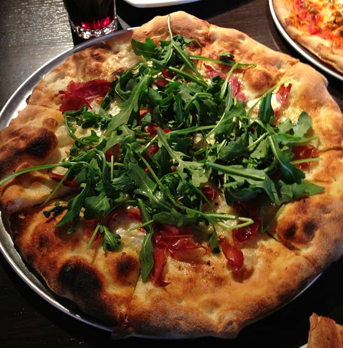 Arugula dancing atop a perfectly charred crust—this isn't just pizza, it's a peppery green celebration on a plate.