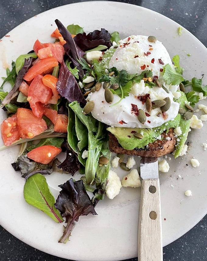 Avocado toast elevated to an art form. That perfectly poached egg waits to cascade golden goodness over creamy avocado and hearty sourdough—a breakfast worthy of your Instagram and your appetite.