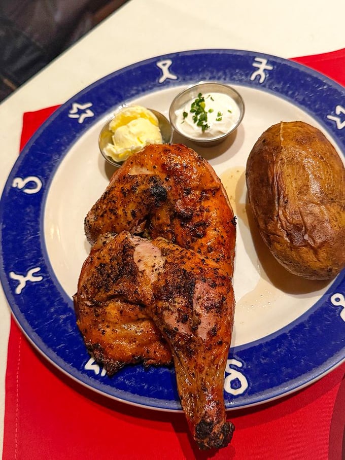 That perfectly charred exterior isn't an accident – it's oak-fired mastery that transforms ordinary poultry into something worth crossing the state for. The baked potato stands ready for duty.