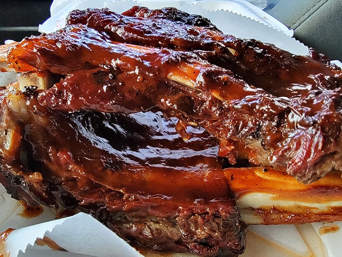 These ribs aren't falling off the bone—they're clinging to it with just enough resistance to prove they were smoked by someone who knows what they're doing.