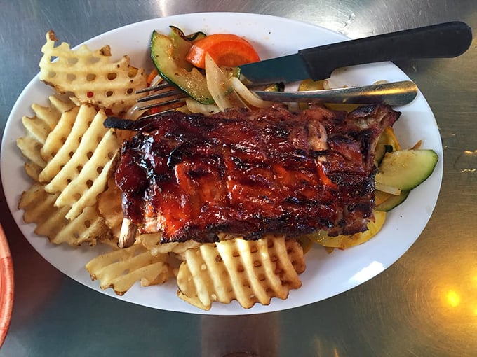 These BBQ ribs don't just fall off the bone—they practically leap into your mouth, bringing along waffle fries that deserve their own fan club.