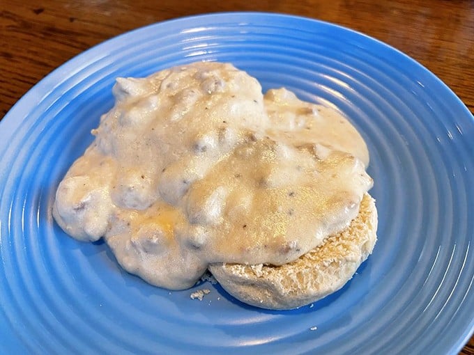 Behold the star attraction: biscuits smothered in velvety sausage gravy. This isn't just breakfast—it's an Ohio morning tradition served on a blue plate.