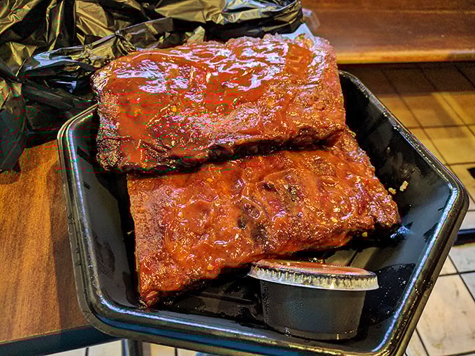 These ribs aren't just falling off the bone—they're practically jumping onto your fork, glistening with that signature sauce that haunts barbecue dreams.