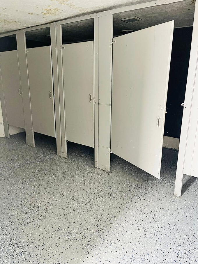 The bathroom stalls tell their own stories—basic, functional, and blissfully unchanged by interior design trends or smartphone charging stations.