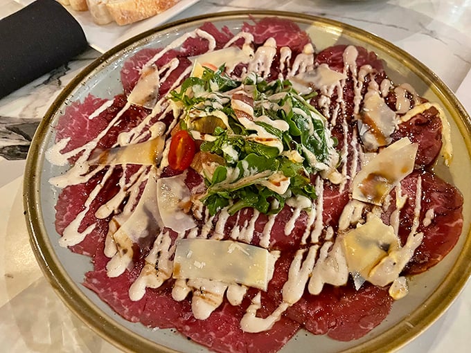 This carpaccio isn't just thinly sliced beef – it's a canvas where creamy sauce, fresh herbs, and shaved cheese create an edible masterpiece worthy of the Louvre.