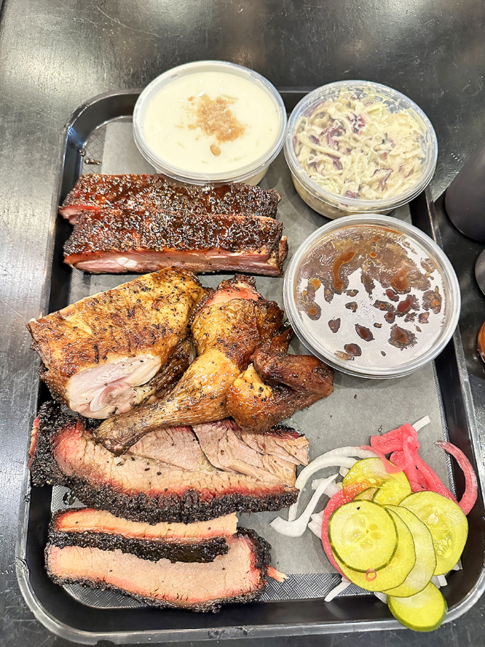 Behold the holy trinity of barbecue perfection: smoke-ringed brisket, succulent ribs, and juicy chicken, flanked by sides that refuse to be overshadowed.