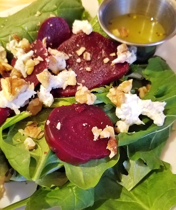 Behold the star attraction – roasted beets nestled among fresh greens, crowned with goat cheese and walnuts. Vegetable royalty, no scepter required.