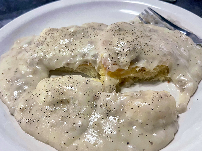 Behold the legendary biscuits and gravy – a velvety river of peppery sausage gravy cascading over golden biscuits. This isn't breakfast; it's an edible hug for your soul.