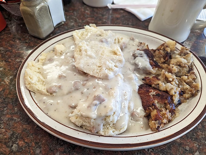 Behold the holy grail – biscuits swimming in peppery sausage gravy alongside crispy hashbrowns. This plate has launched a thousand food pilgrimages.