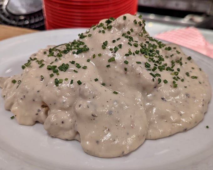 Behold the holy grail of comfort food—biscuits drowning in peppery country gravy, sprinkled with chives that add color but know their supporting role.