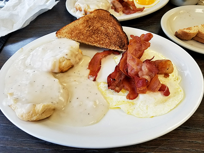 Biscuits swimming in creamy gravy alongside perfectly cooked eggs and bacon – the breakfast equivalent of hitting all green lights on your morning commute.