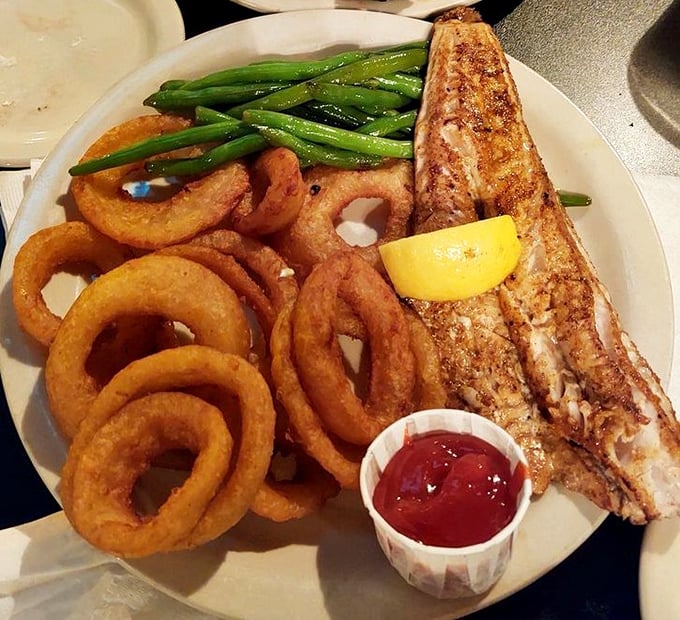 The blackened walleye arrives like a flavor ambassador from Lake Erie – perfectly seasoned, flaky, and flanked by golden onion rings that demand attention.