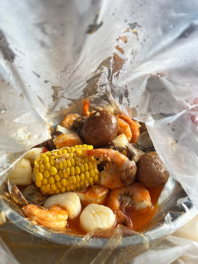 Behold the steaming bag of oceanic treasures that turns civilized diners into happy, sauce-covered shell-cracking warriors.