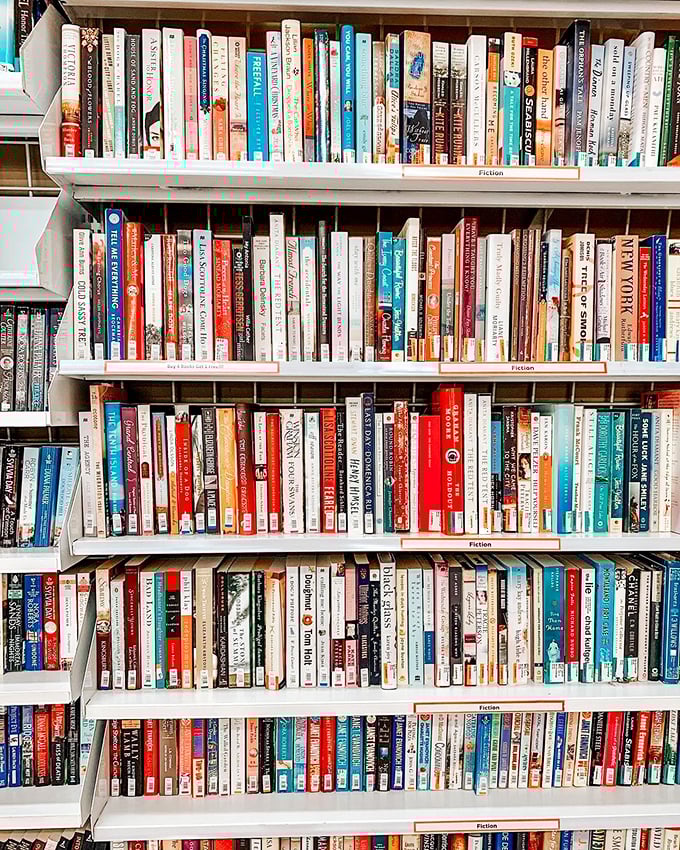 The fiction section houses thousands of literary journeys for less than a coffee. Some books arrive with beach sand still between their pages.
