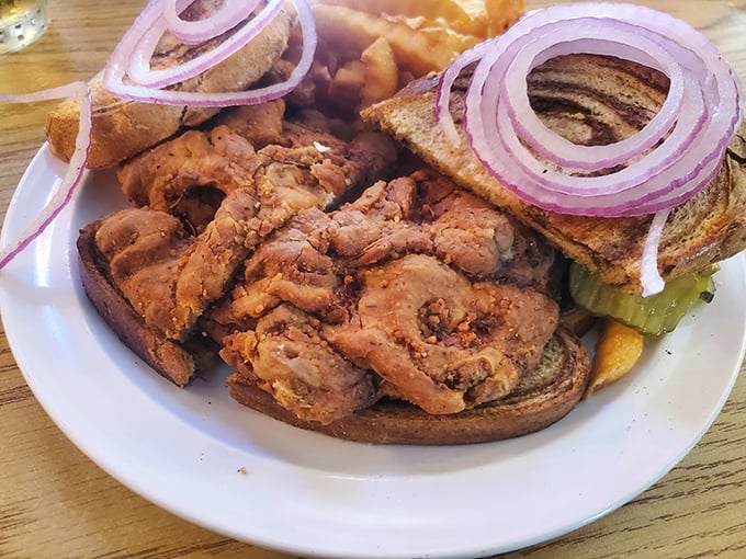 The legendary brain sandwich arrives: golden-fried, crispy exterior giving way to a creamy interior, with purple onions adding sharp contrast to each bite.