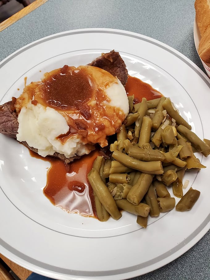 Mashed potatoes and gravy pooling into a tender steak with green beans on the side—a plate that whispers, "Everything's going to be okay."