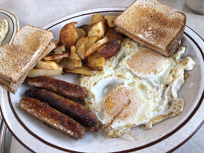 This plate means business – eggs, sausage, potatoes, and toast assembled like a delicious breakfast battalion ready for action.