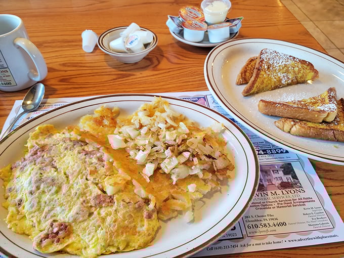 Breakfast perfection on a plate: a golden omelet nestled beside home fries that achieve the holy grail of crispy-outside, fluffy-inside texture.