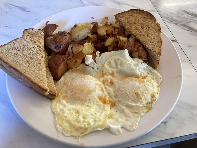 Sunny-side up eggs with perfectly crisped home fries—the breakfast that makes you question why anyone would ever invent cereal.