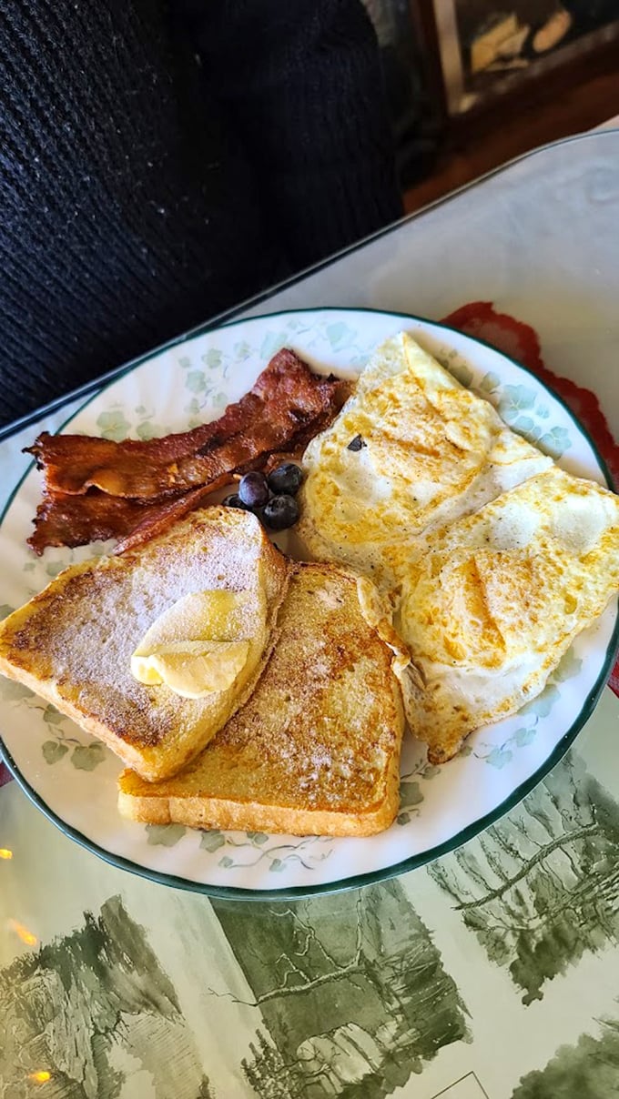 Breakfast perfection on a plate: golden toast, perfectly cooked eggs, and bacon that would make even vegetarians question their life choices. 