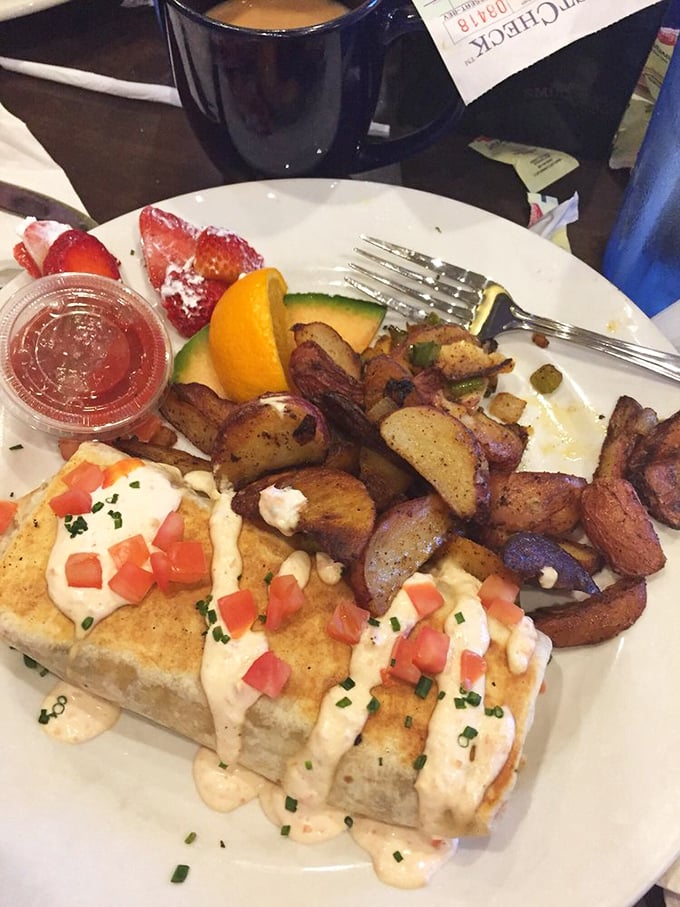 This isn't just breakfast—it's edible architecture. Creamy sauce, diced tomatoes, and home fries creating a savory skyline worth admiring.