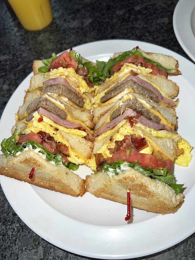 Architectural marvel or breakfast masterpiece? This towering club sandwich defies gravity and good sense, yet somehow makes perfect culinary logic.