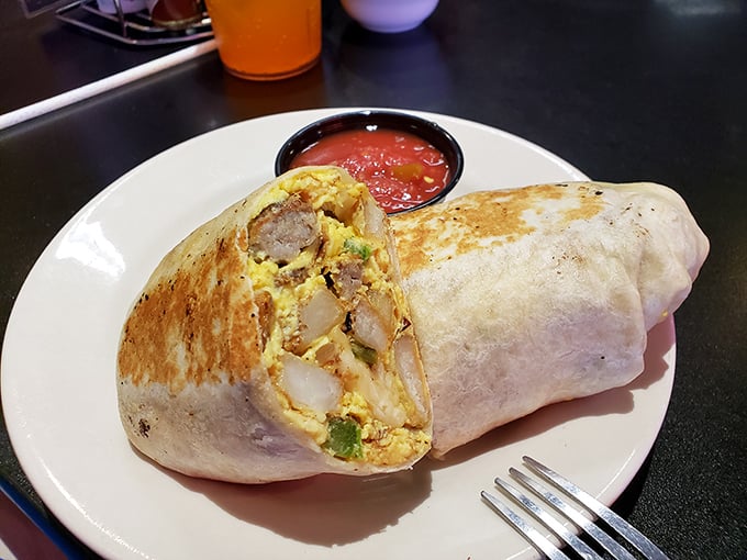 Behold the breakfast burrito in its natural habitat—gloriously stuffed, perfectly grilled, and accompanied by salsa that means business. This isn't a meal; it's a commitment. 
