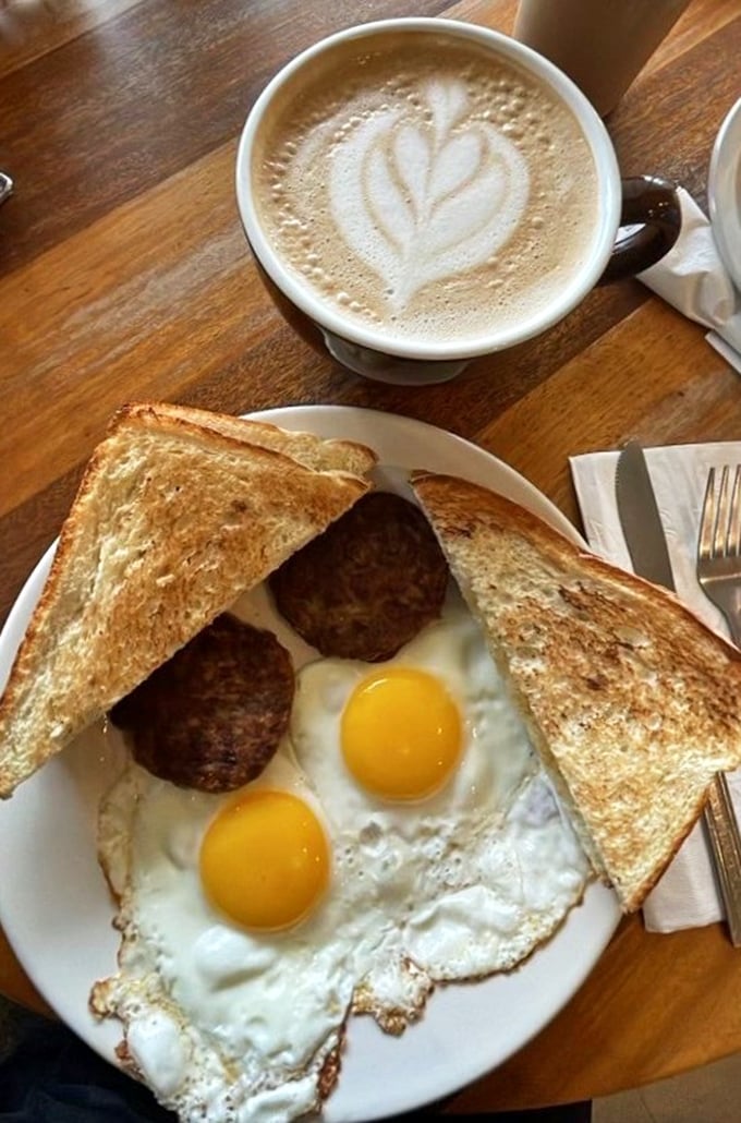 Sunny-side up eggs with perfectly browned sausage patties and golden toast—the breakfast equivalent of winning the lottery on a Tuesday morning.