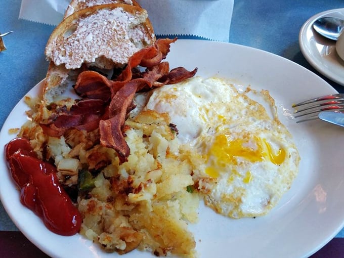 Breakfast perfection doesn't need fancy plating—just perfectly crispy home fries, eggs with that sunset-yellow yolk, and bacon that shatters like glass.