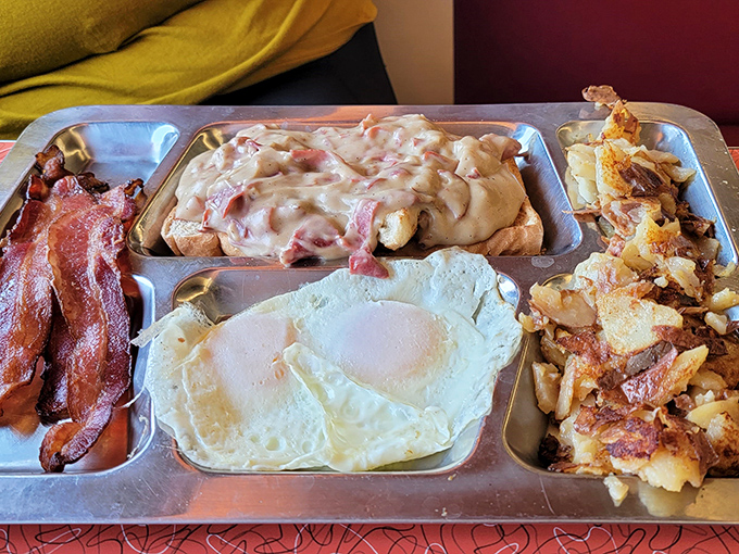 This isn't just breakfast—it's a magnificent metal tray of morning glory with eggs, bacon, potatoes, and gravy that could fuel a cross-country flight.