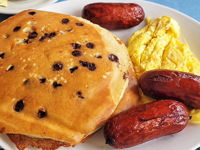 Blueberry pancakes that look like they're auditioning for a breakfast hall of fame, flanked by sausages standing guard against hunger.